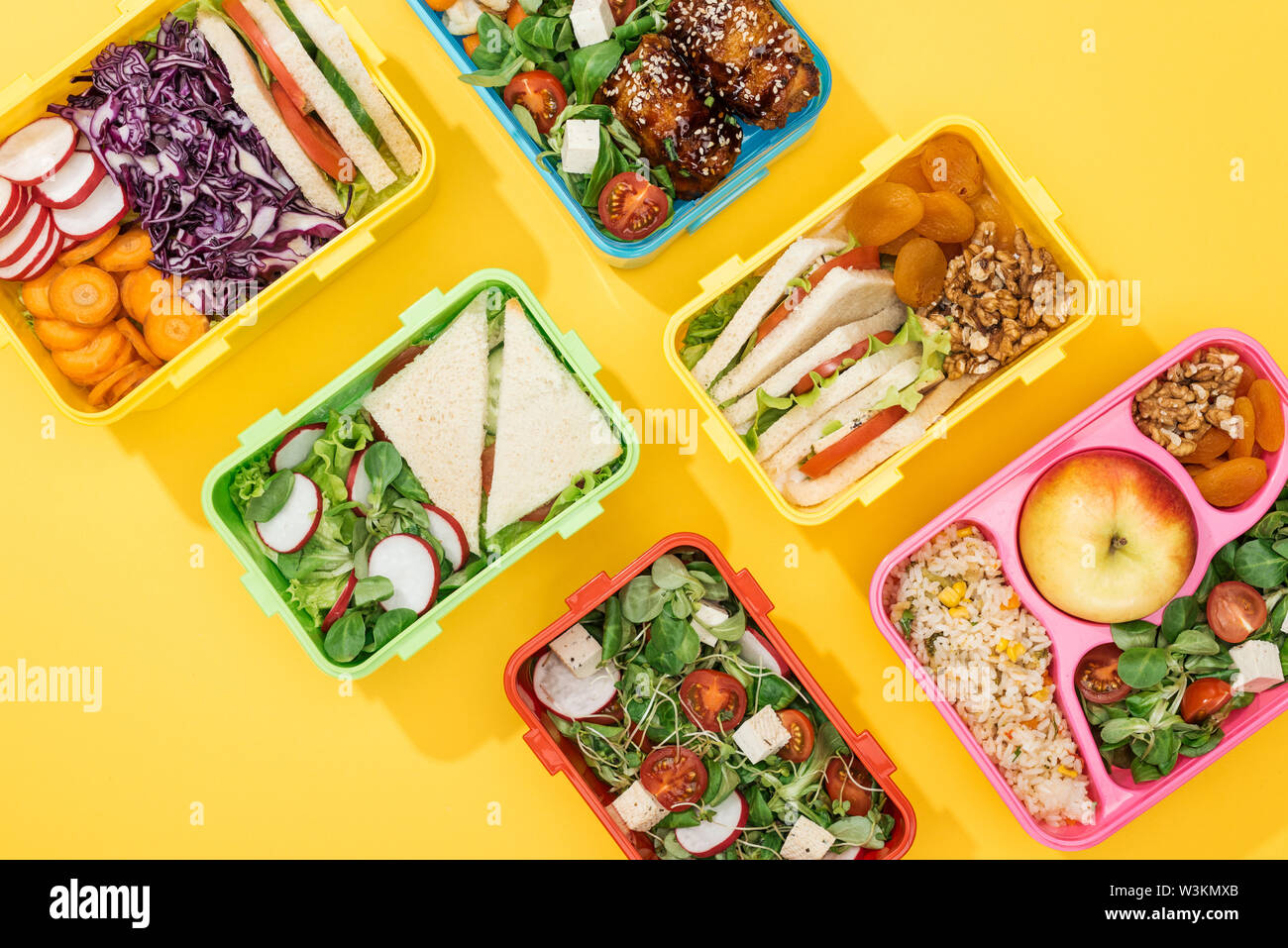 top view of lunch boxes with food on yellow background Stock Photo - Alamy