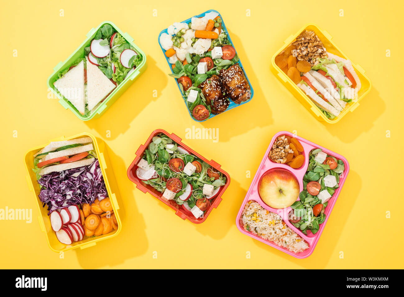 top view of lunch boxes with fresh food on yellow background Stock ...