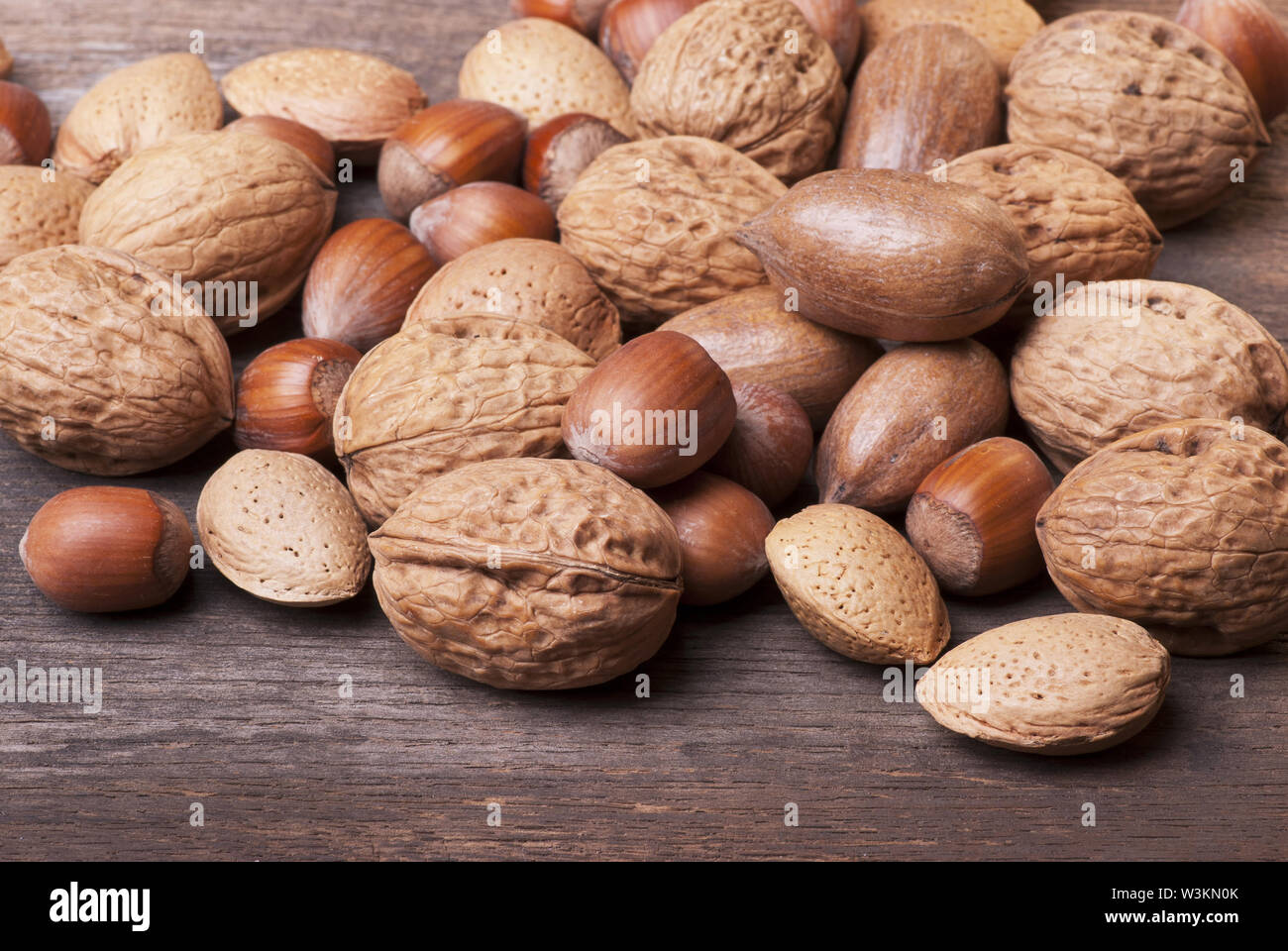 closeup of different types of dried fruit including pecans, almonds and ...
