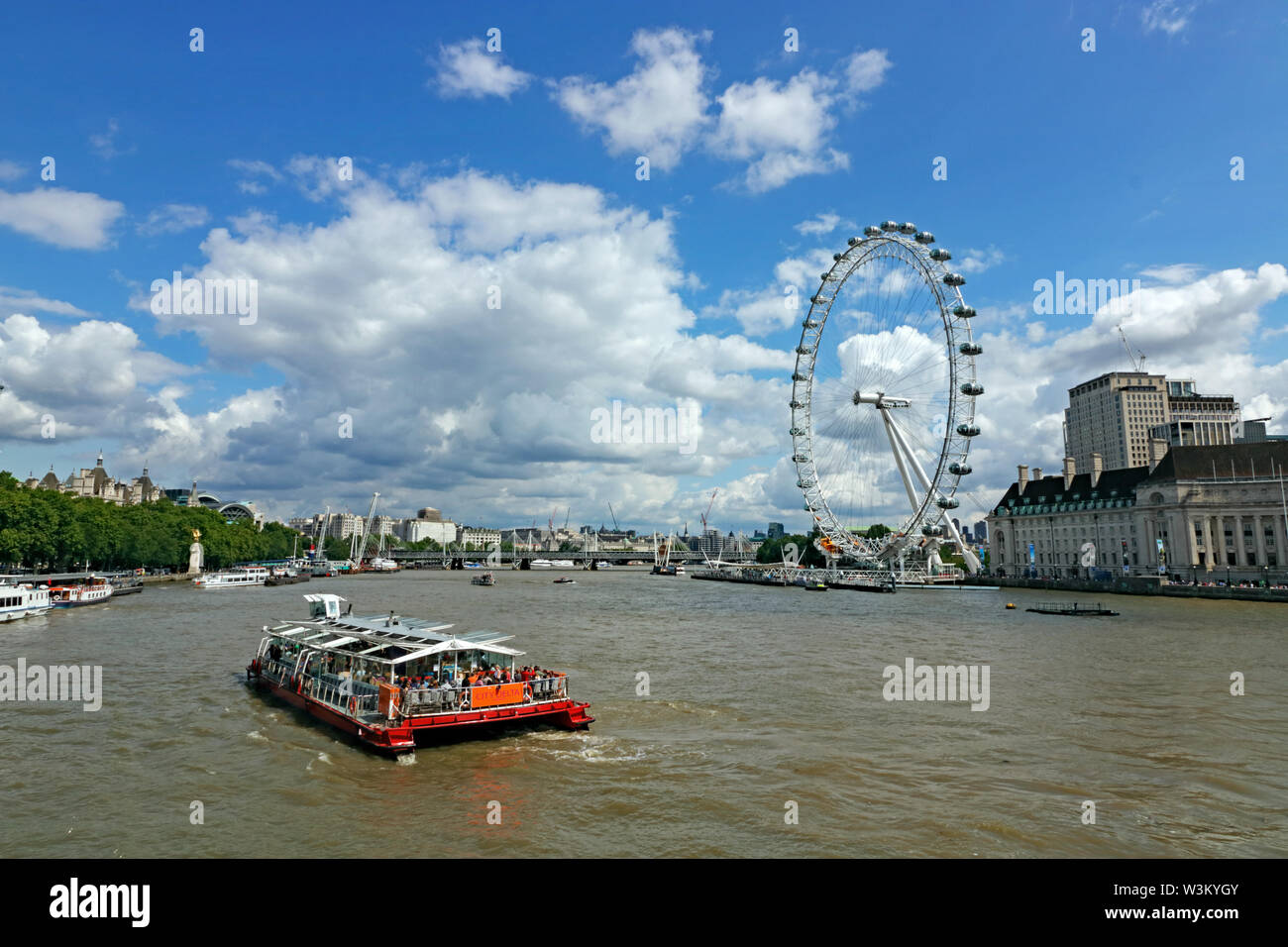 Boats on the River Thames in front of County Hall and the London Eye ...