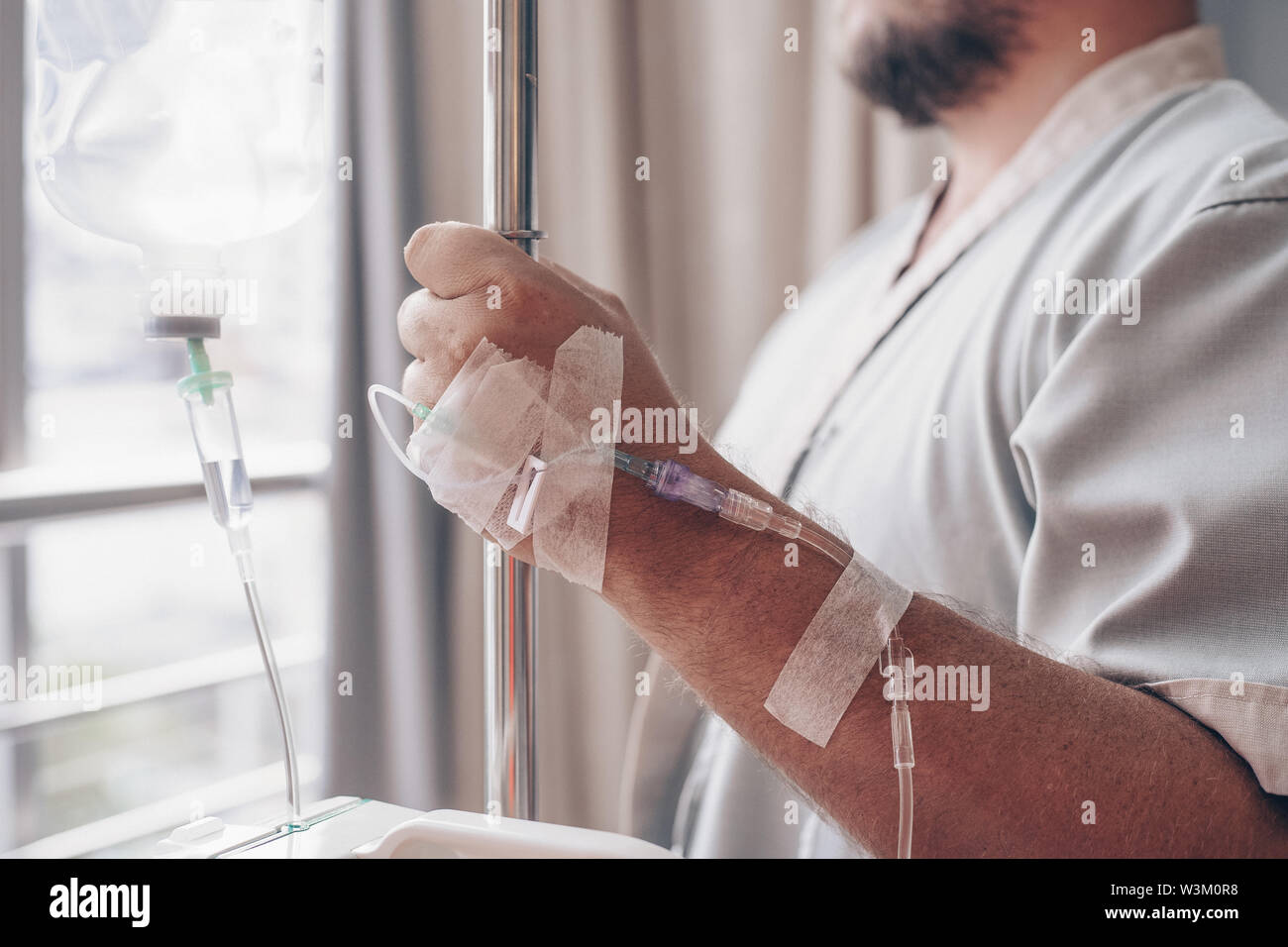 Dropper in a man's hand in a hospital. close-up Stock Photo - Alamy
