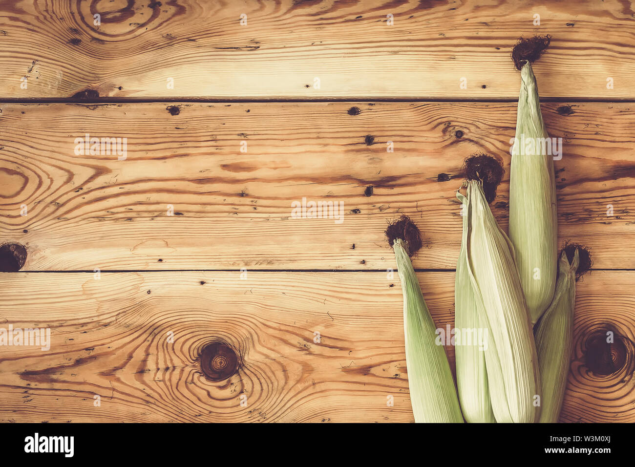 Fresh raw corn cobs on wooden background. Raw corn with skin. Sweet ...