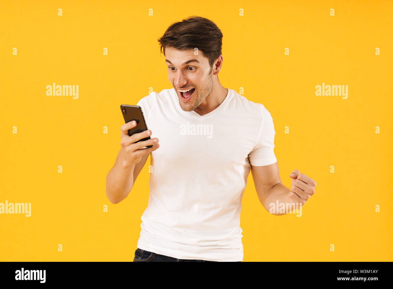 Image of a happy excited shocked young man in casual white t-shirt ...