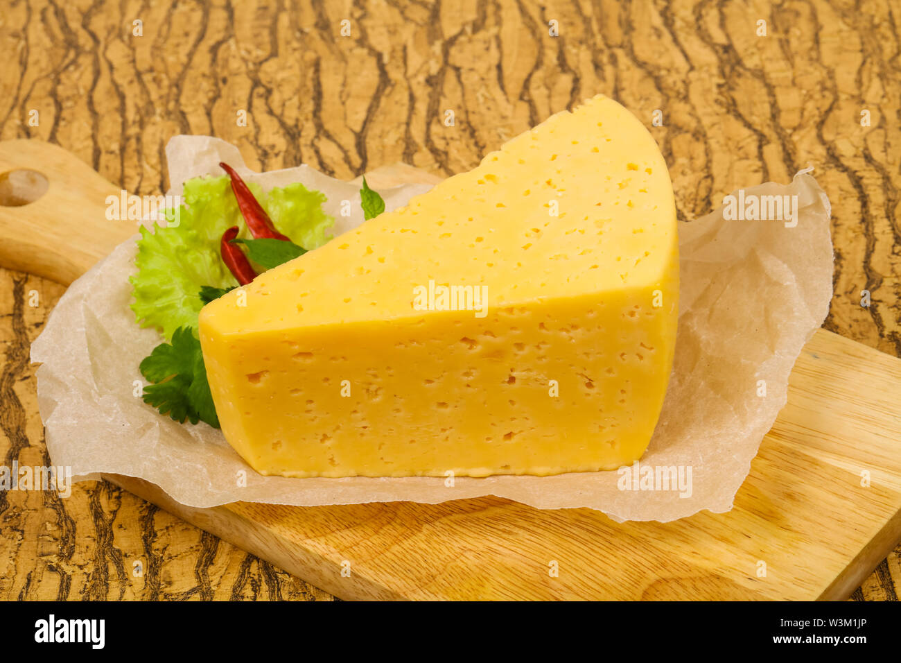 Piece. of Yellow Cheese served herbs Stock Photo - Alamy