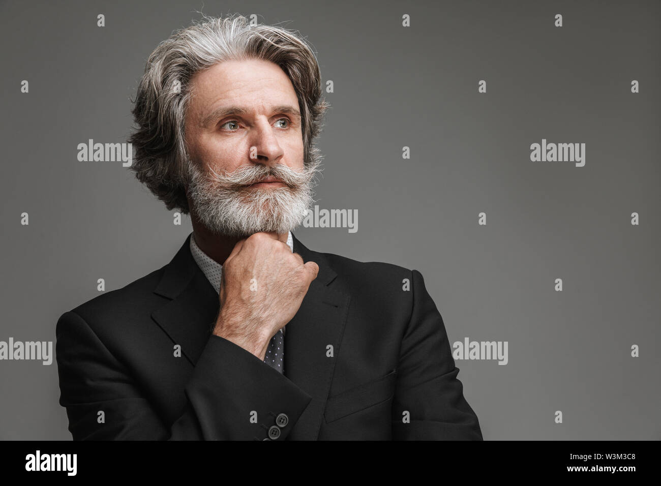 Image of handsome adult businessman wearing formal black suit looking ...