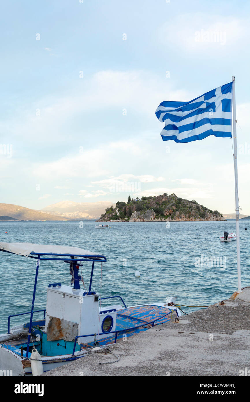 National symbol of Greece, blue-white greek flag on flagpole, sea water ...