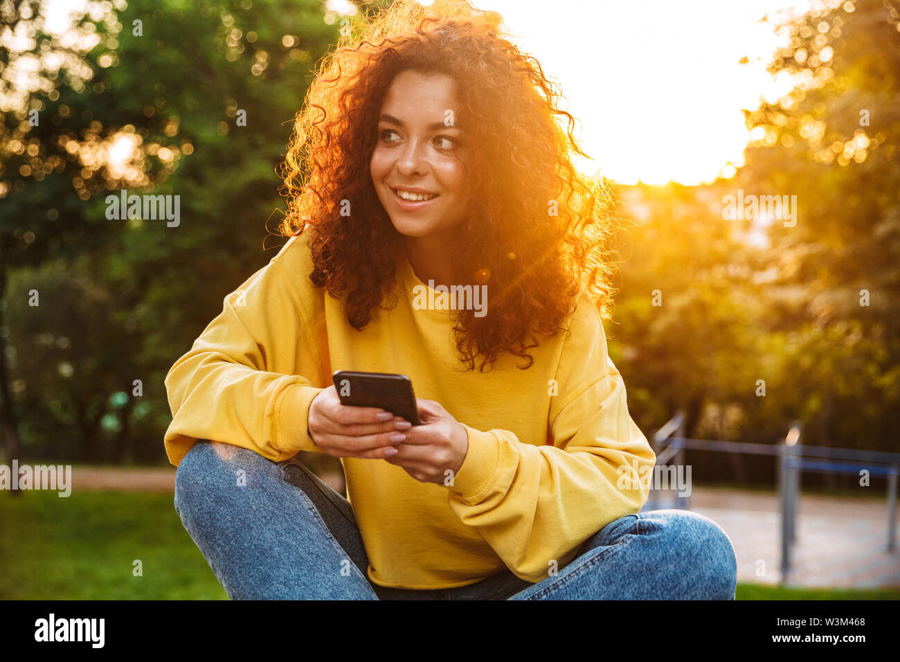 Image of a cheerful optimistic cute young student curly girl sitting on ...