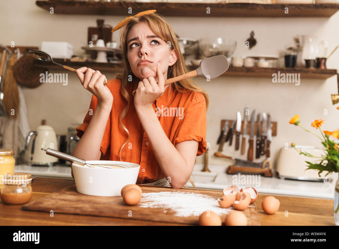 Picture of a thoughtful confused sad young blonde girl chef cooking at ...