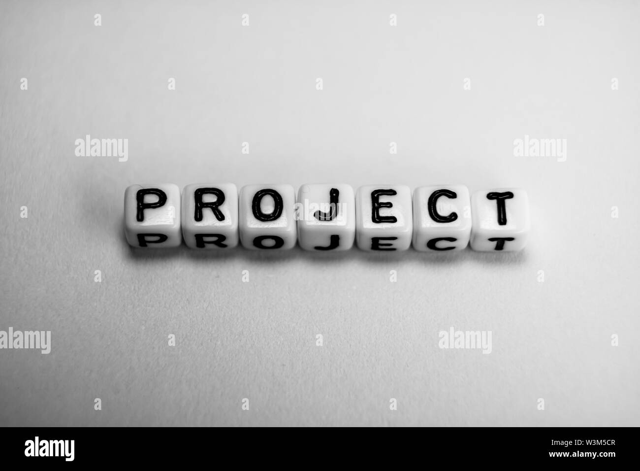 White cubes with word PROJECT on white paper background and dark ...