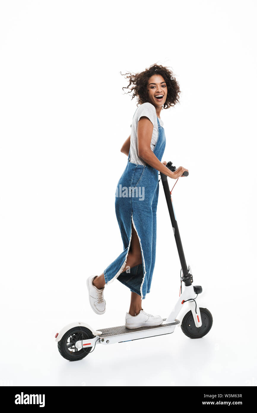 Image of excited african american woman dressed in denim overalls ...