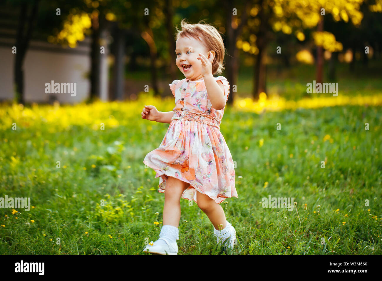 Happy cute little girl running on the grass in the park. Happiness ...