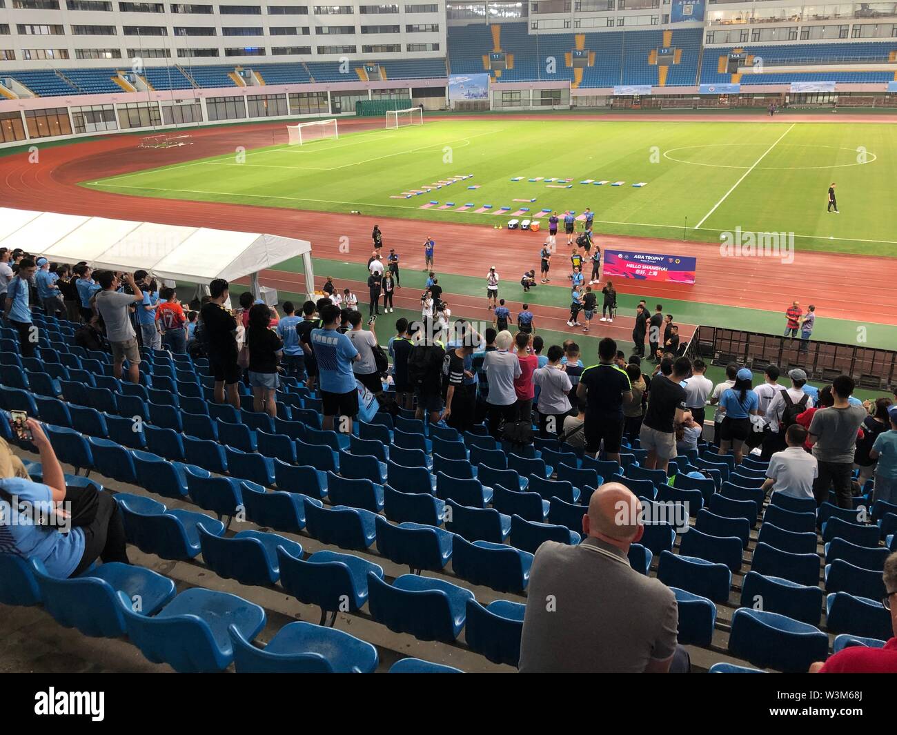 Fans watch the Manchester City training session at the Yuanshen Stadium ...