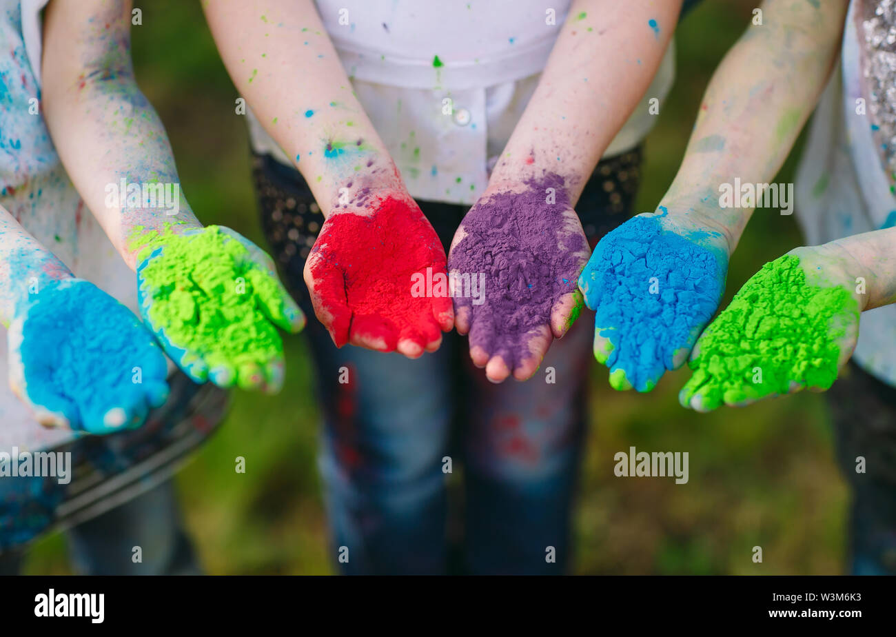 Hands Palms of young people covered in purple, yellow, red, blue Holi ...