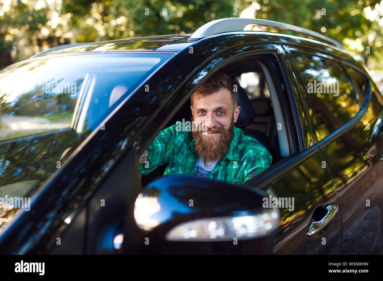Bearded man in the car. Young man driving his car Stock Photo - Alamy