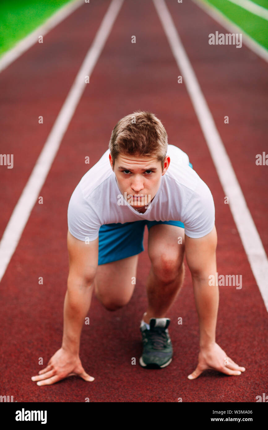 Athletic man on track starting to run. Healthy fitness concept with ...