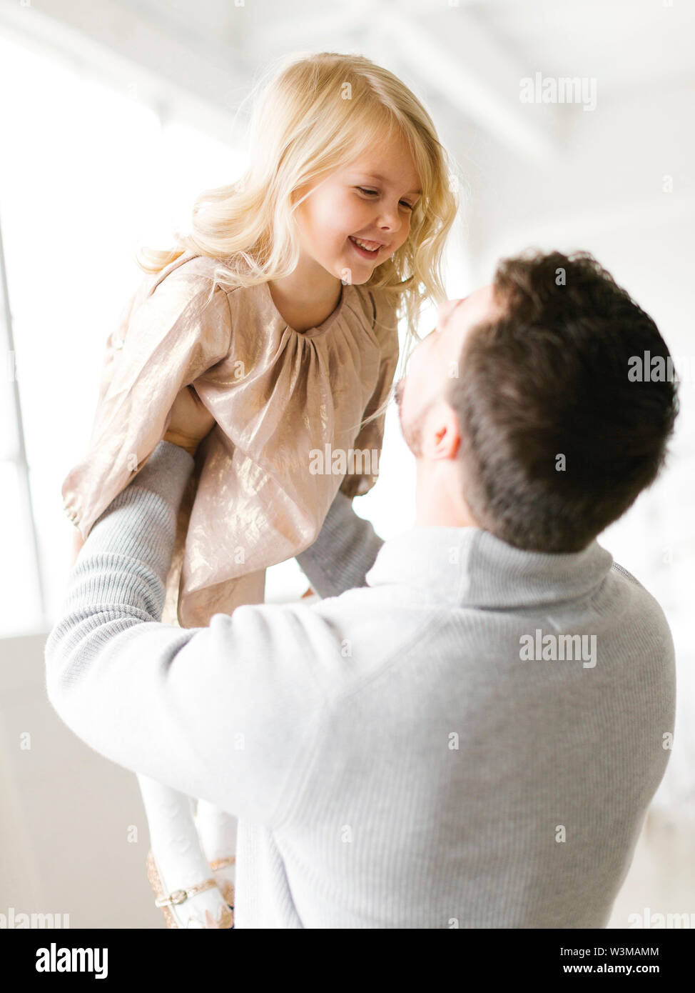 Mid adult man lifting his daughter Stock Photo - Alamy