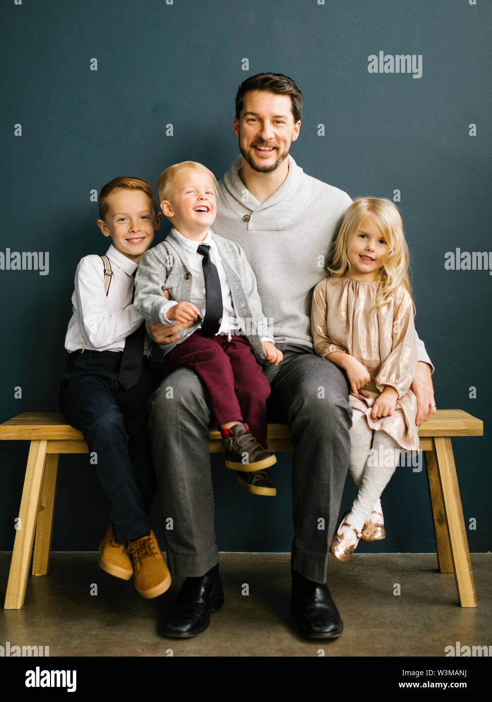 Father sitting with his three children Stock Photo - Alamy