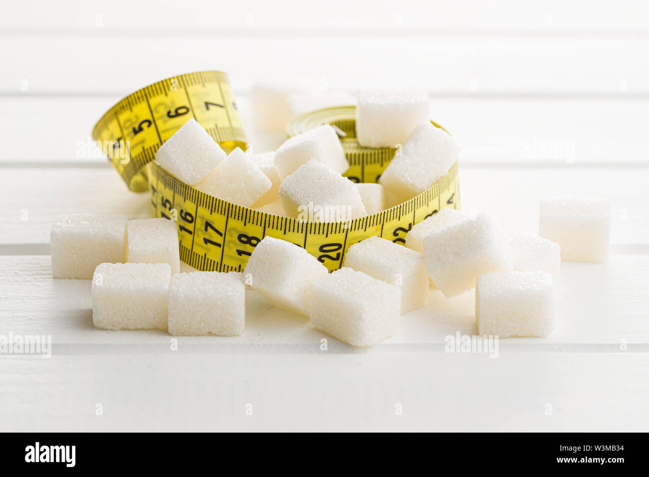 White sugar cubes and measuring tape on white table Stock Photo - Alamy