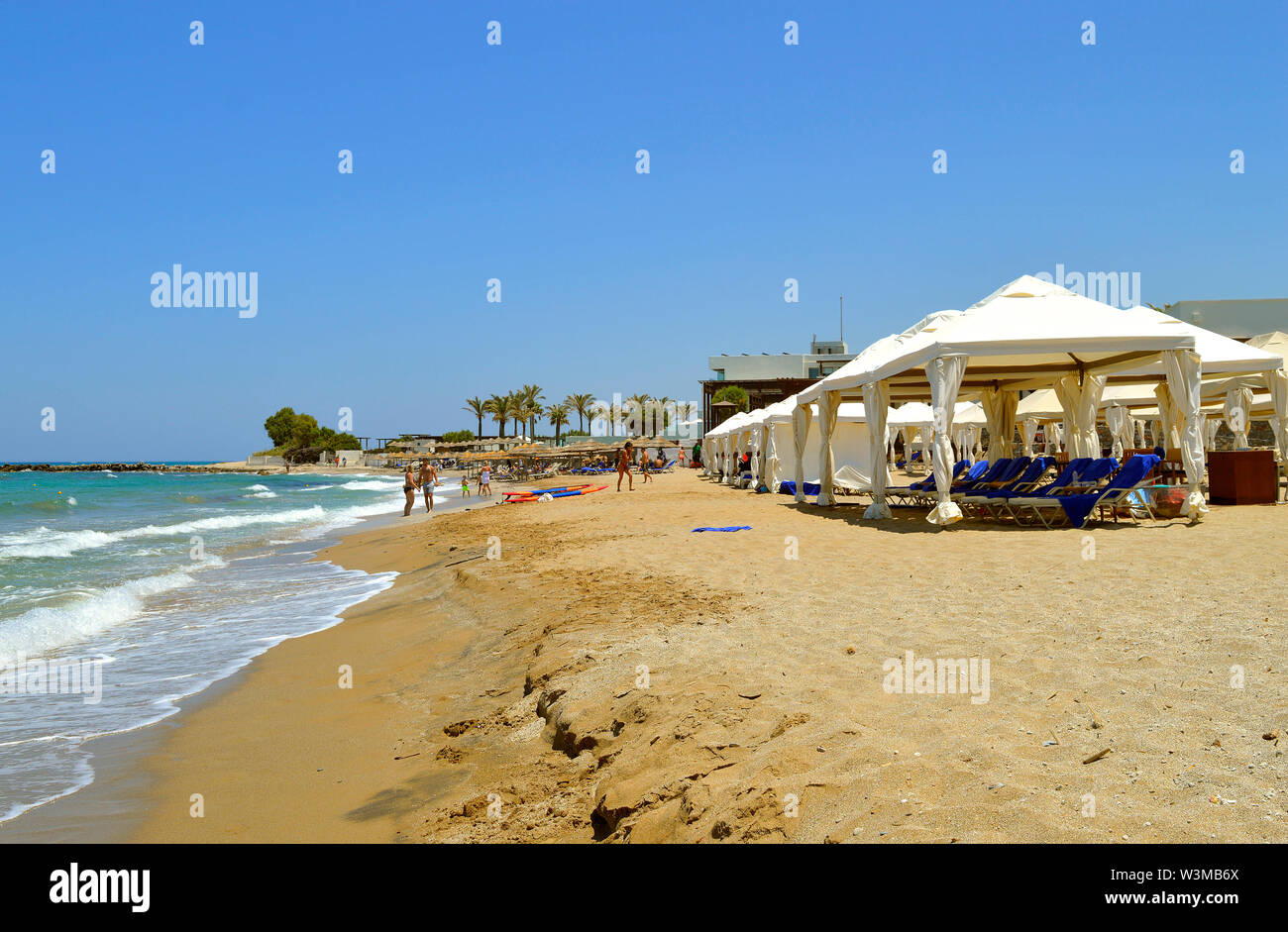 Tourists sunbathing under gazebos on Gouves beach in Crete the largest ...