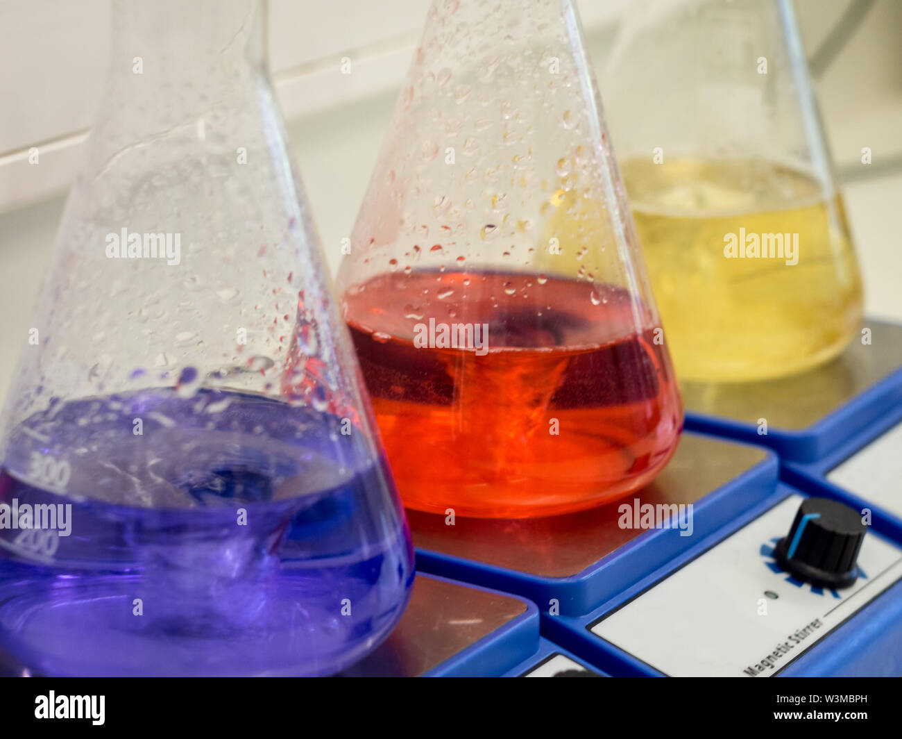 Erlenmeyer flasks with colorful solutions closeup Stock Photo - Alamy