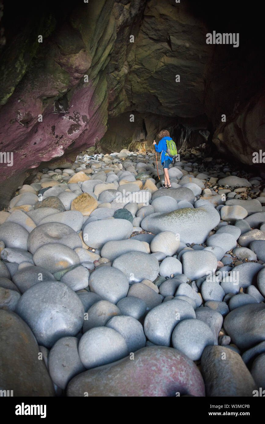 Teenage boy exploring cave with rocks in La Jolla, California Stock ...