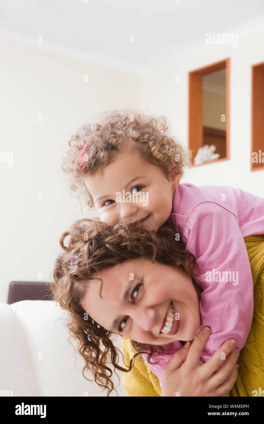 Girl on her mother's back Stock Photo - Alamy