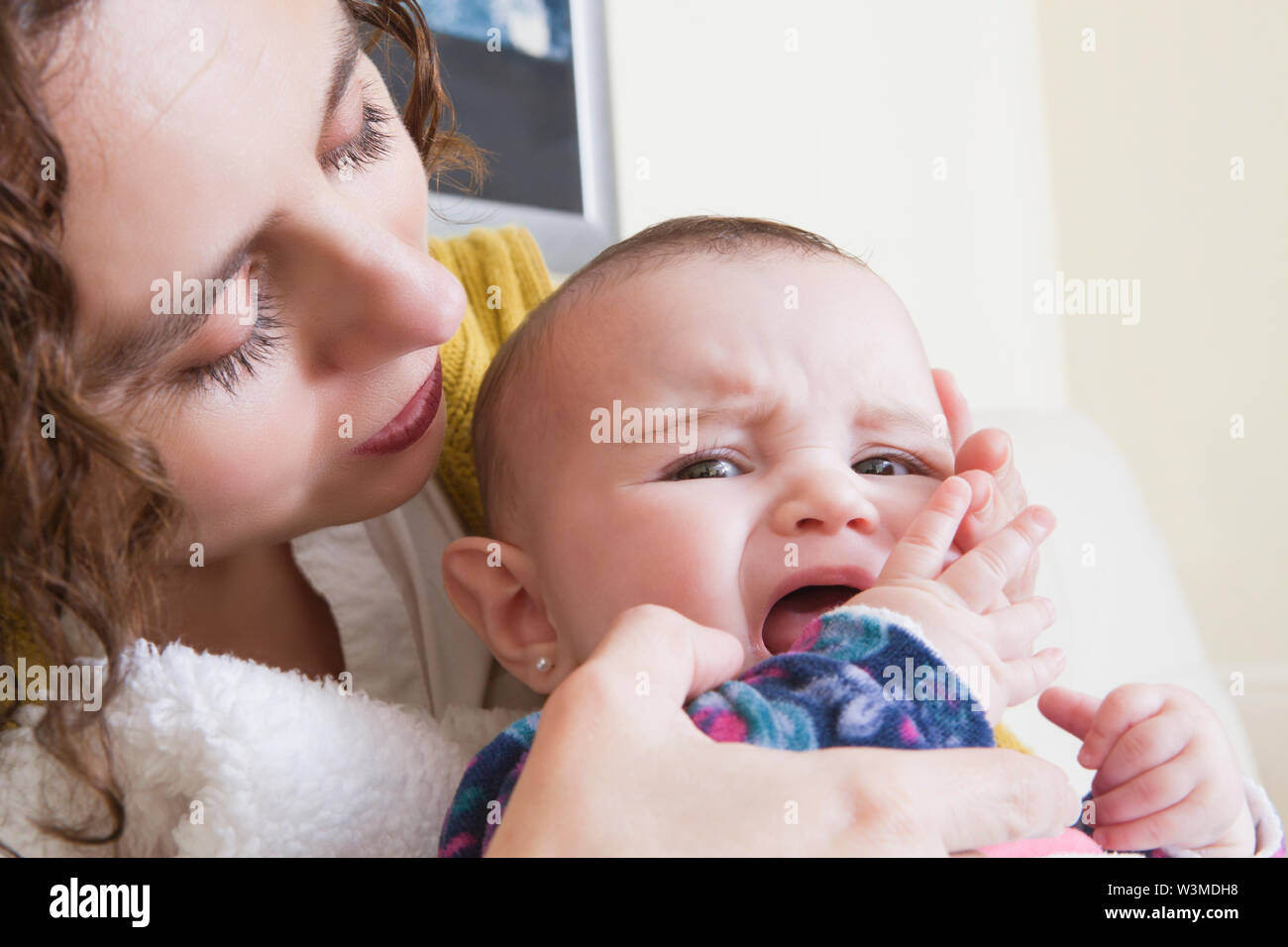 Mother holding crying baby girl Stock Photo - Alamy
