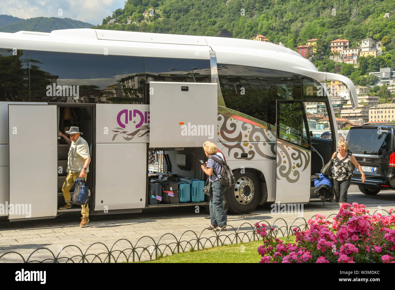 COMO, LAKE COMO, ITALY - JUNE 2019: People getting off a coach in the ...