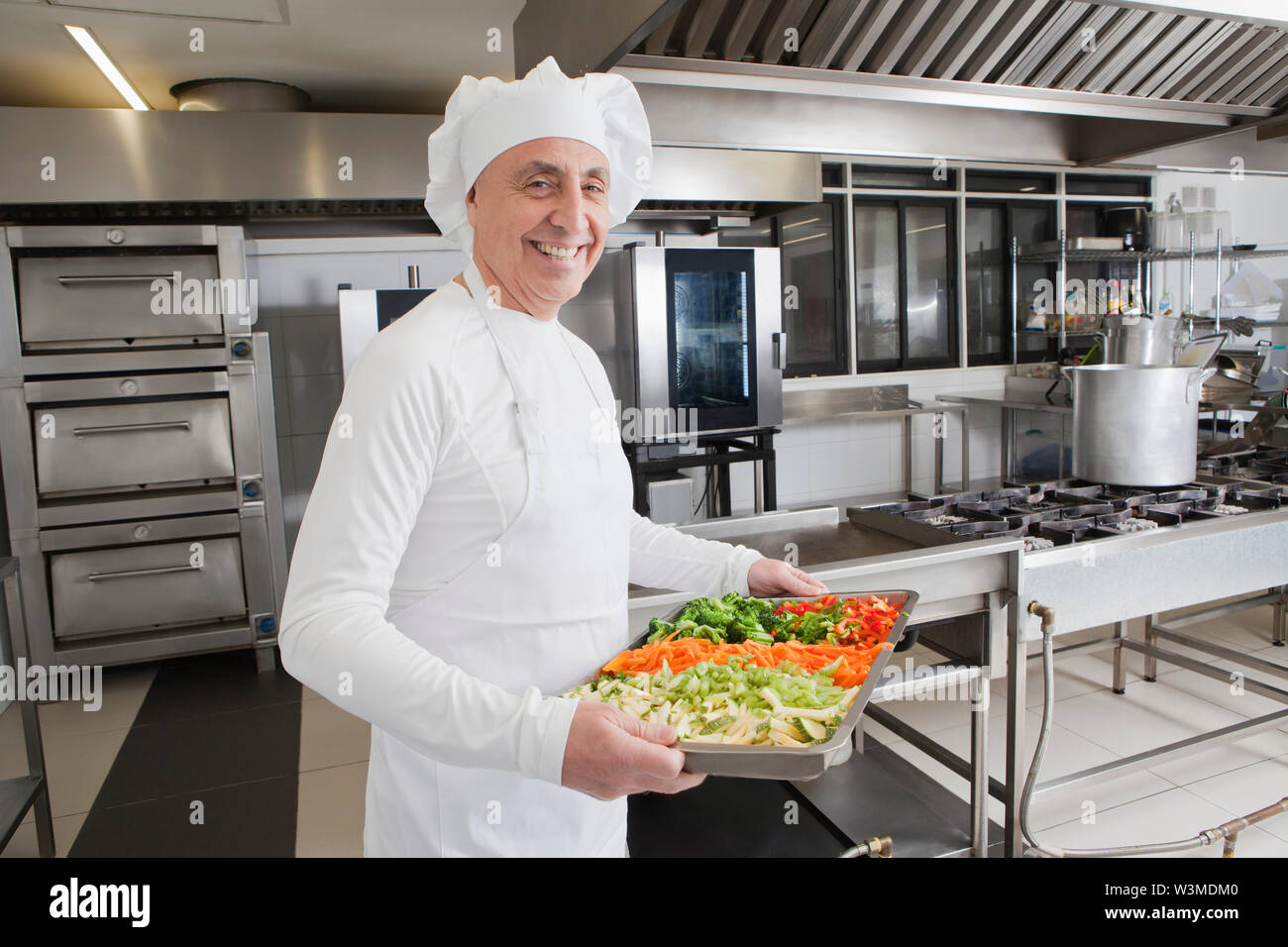 Chef smiling holding tray hi-res stock photography and images - Alamy