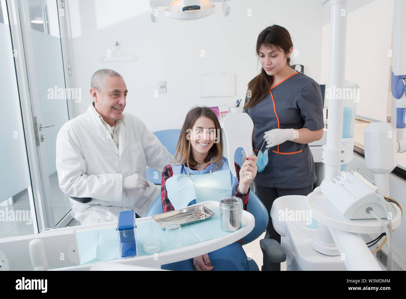 Patient smiling at mirror in dentist's surgery Stock Photo - Alamy
