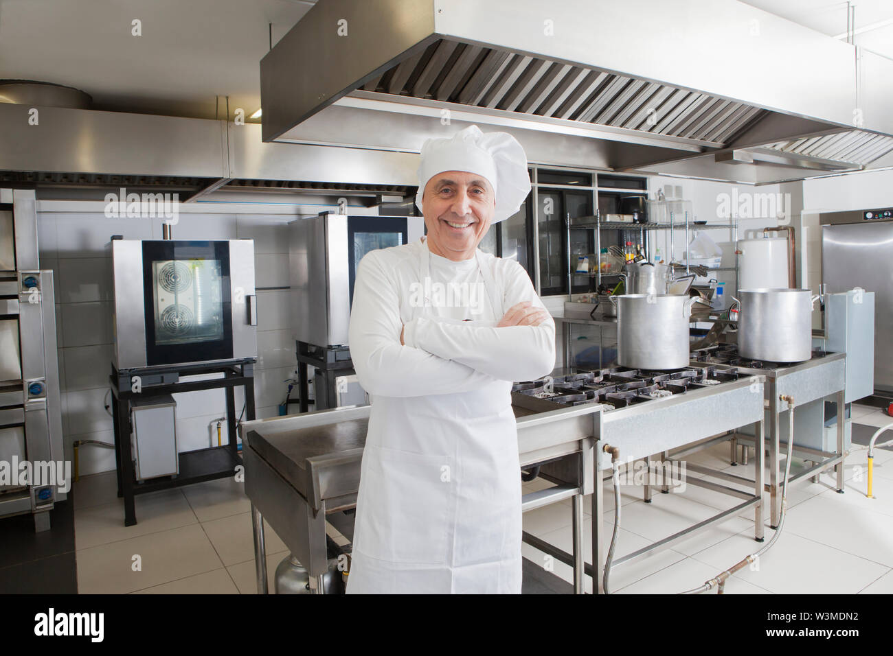 Chef smiling in commercial kitchen Stock Photo - Alamy