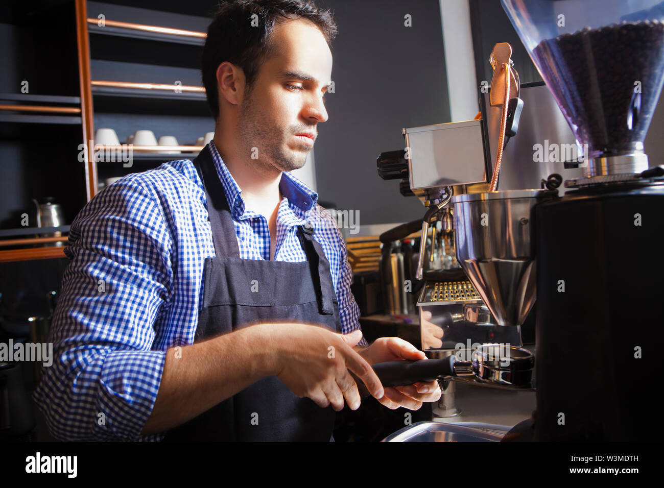 Barista collecting ground coffee in portafilter Stock Photo - Alamy