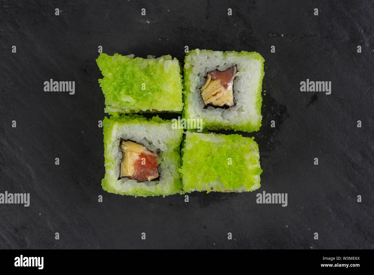Green fish roe sushi on black surface Stock Photo - Alamy