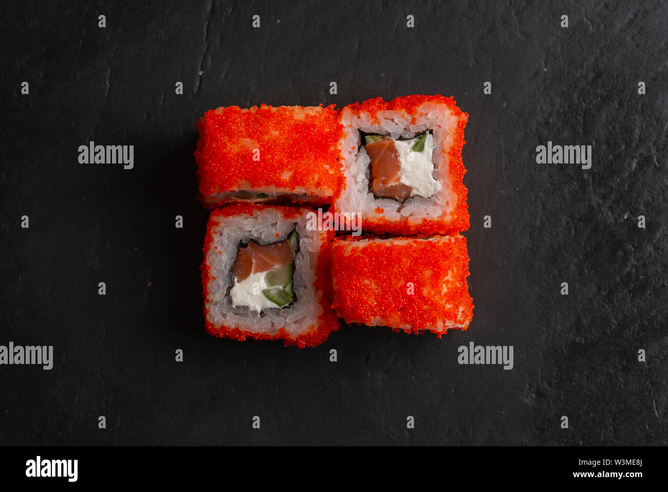 Red fish roe sushi on black surface Stock Photo - Alamy