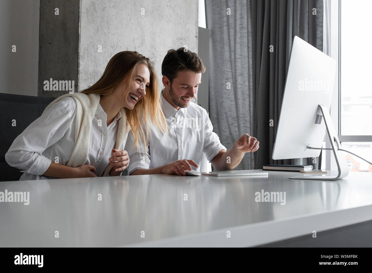 Colleagues laughing at desk Stock Photo - Alamy