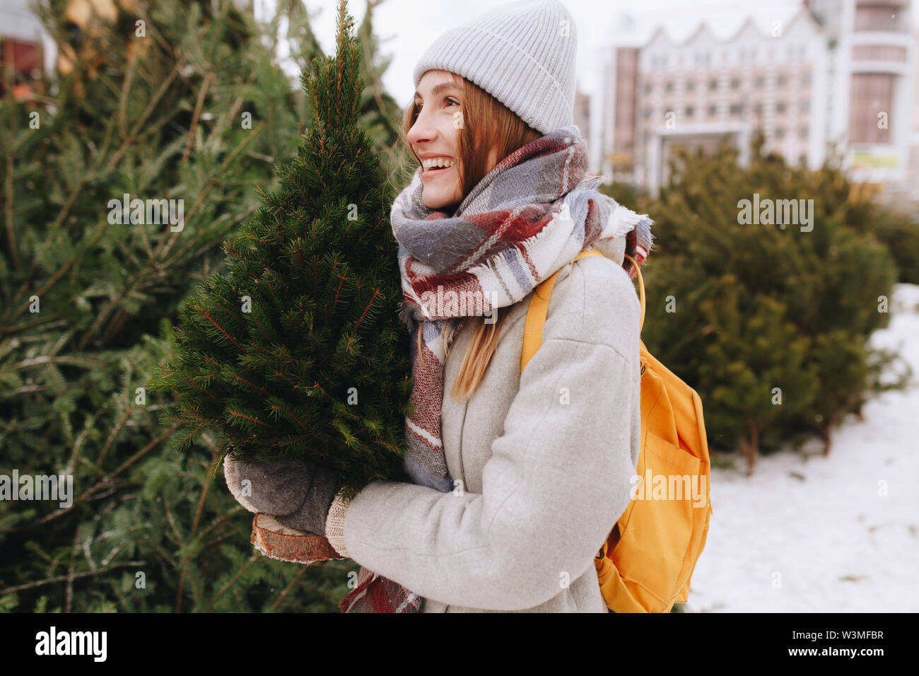 Young woman carrying small Christmas tree Stock Photo - Alamy