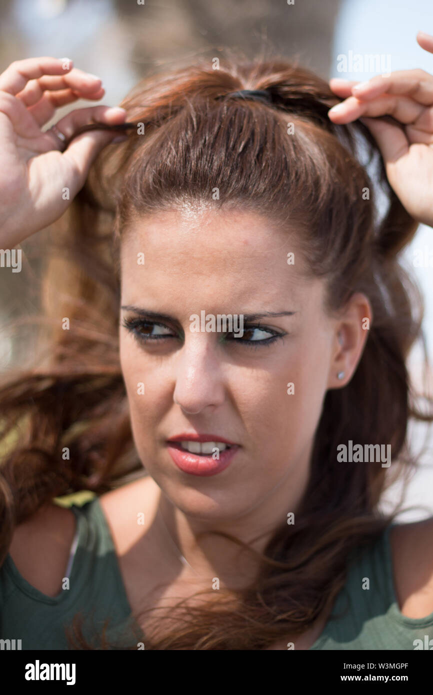 Brunette woman side portrait standing outside, looking to the left ...