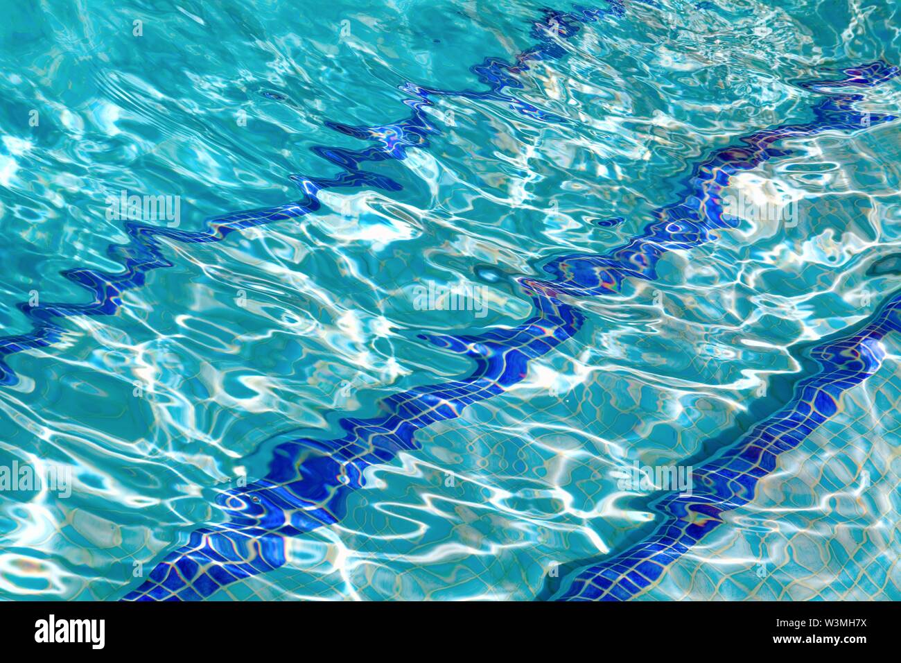 Abstract patterns formed by strong sunlight on the surface of water in ...