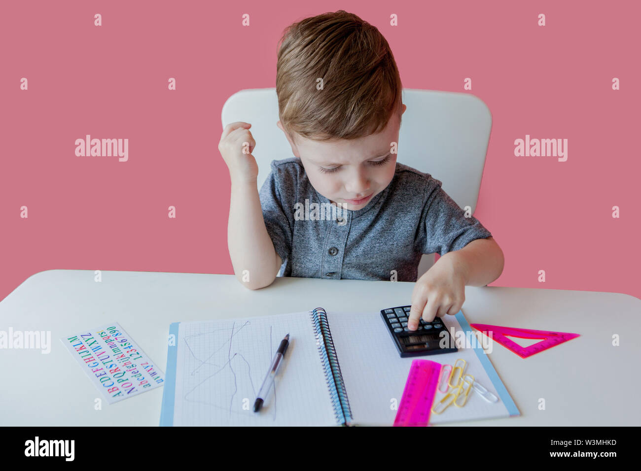 Portrait of cute kid boy at home making homework. Little concentrated ...