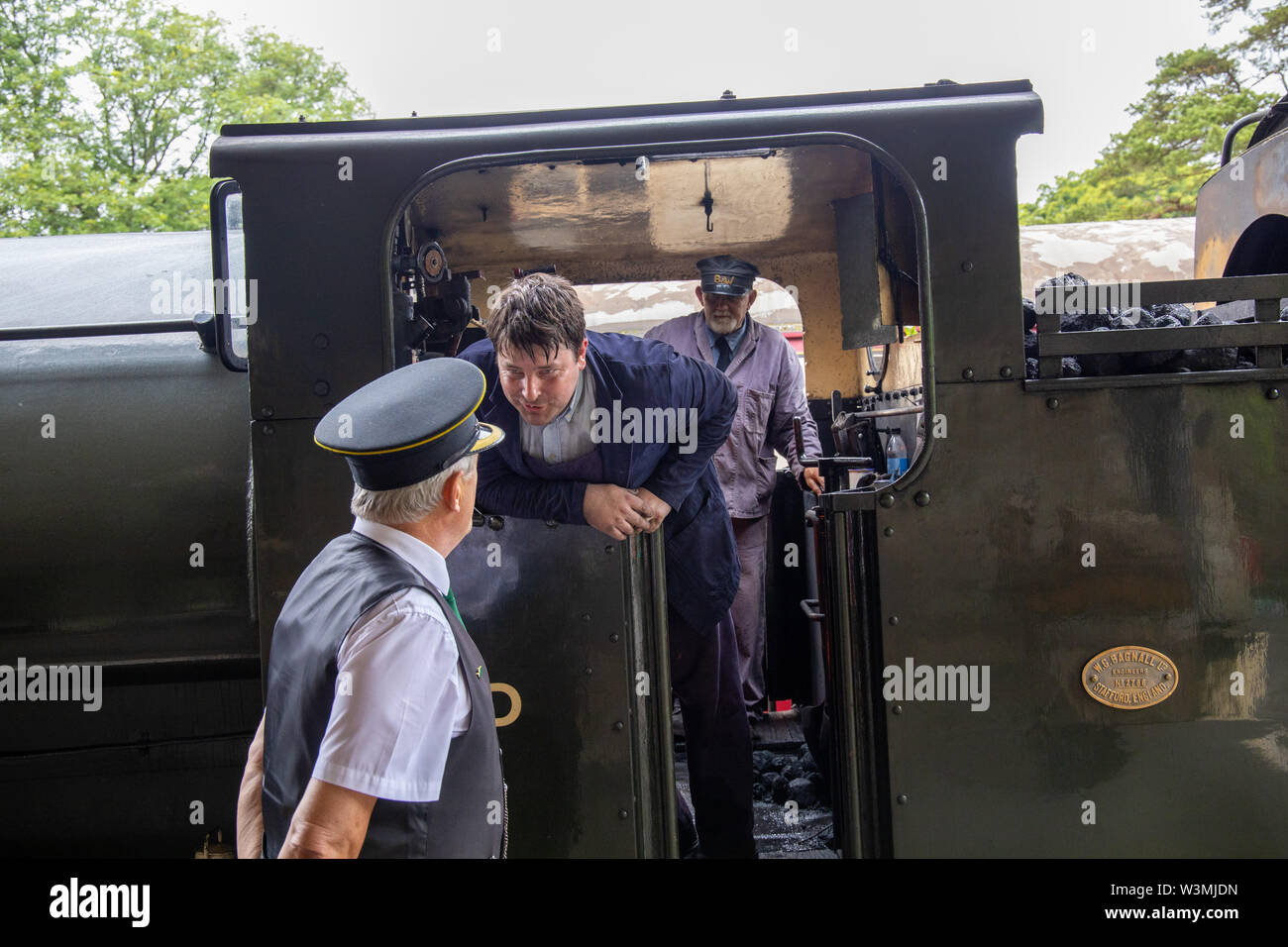 Driver and fireman talk to station master on the footplate at Bodmin ...