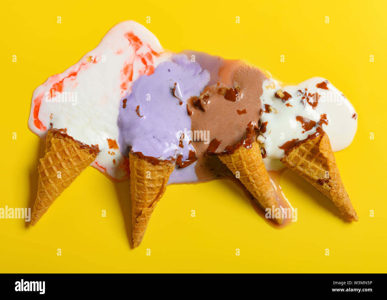 top view multiple flavor ice cream cones melted on yellow background ...