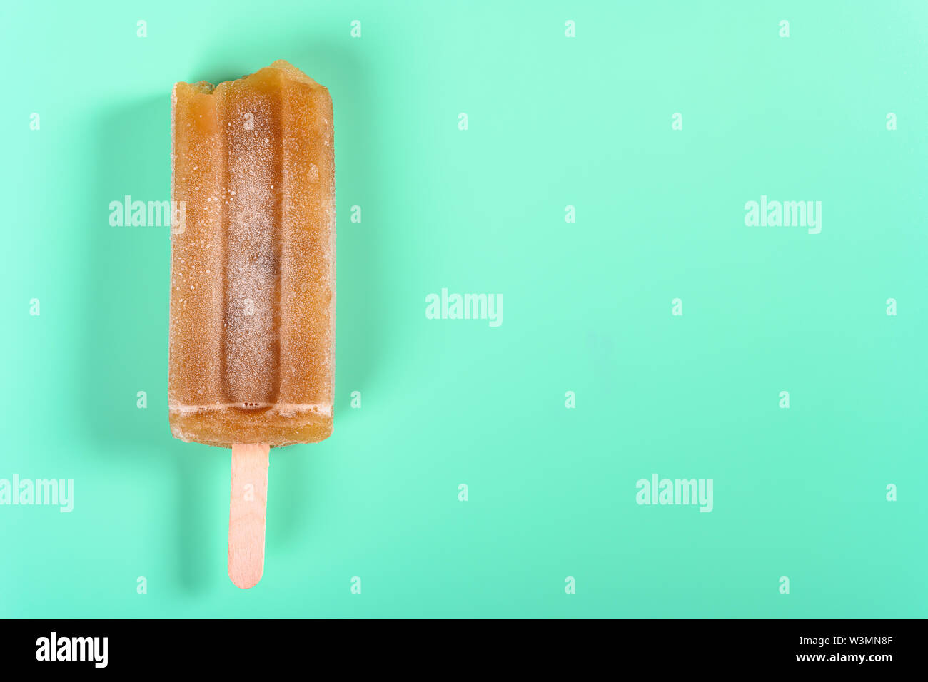 red bean popsicle with some bites on light green background Stock Photo ...