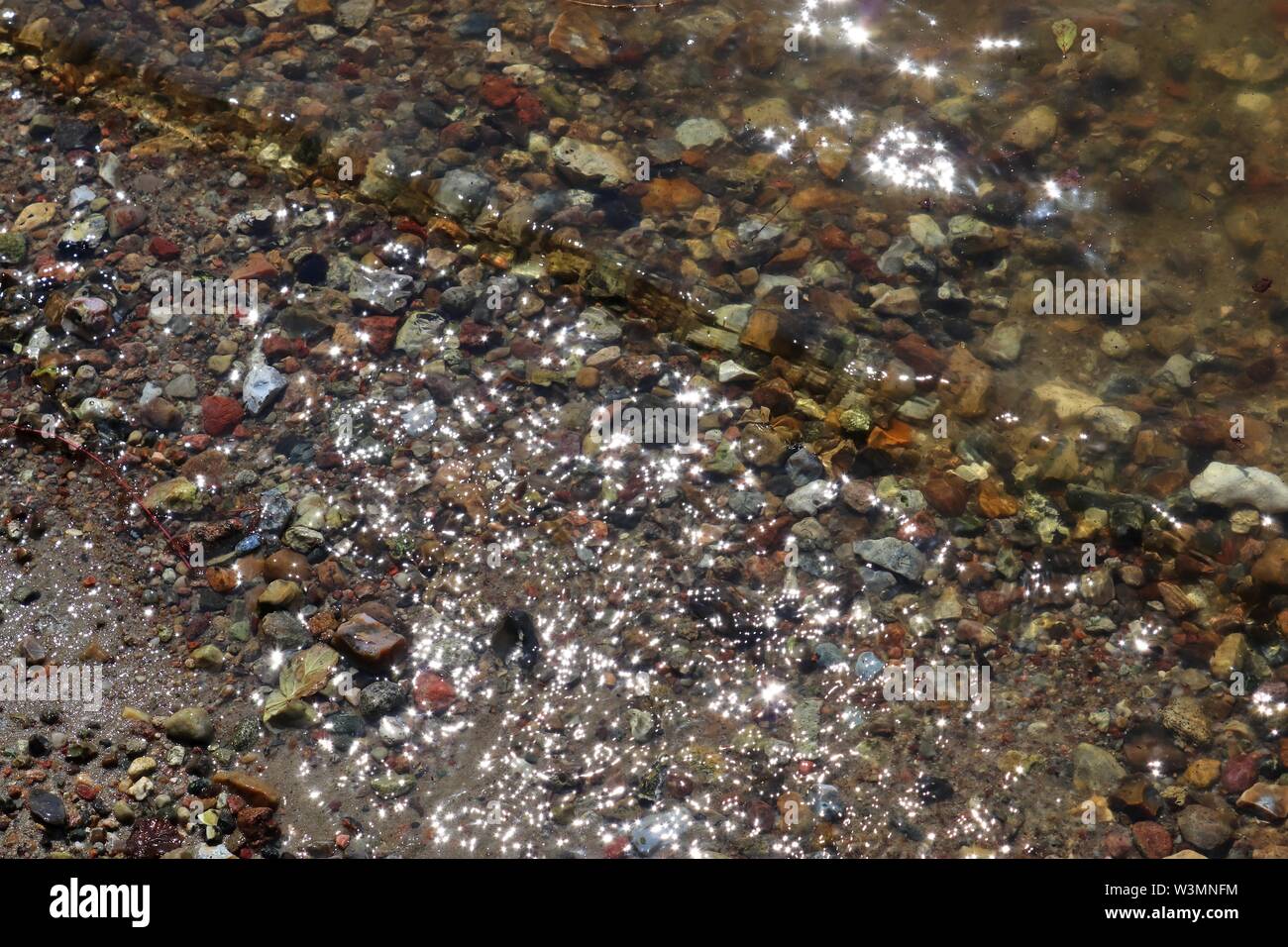 Beautiful water surfaces at a lake with reflections of sunlight and ...