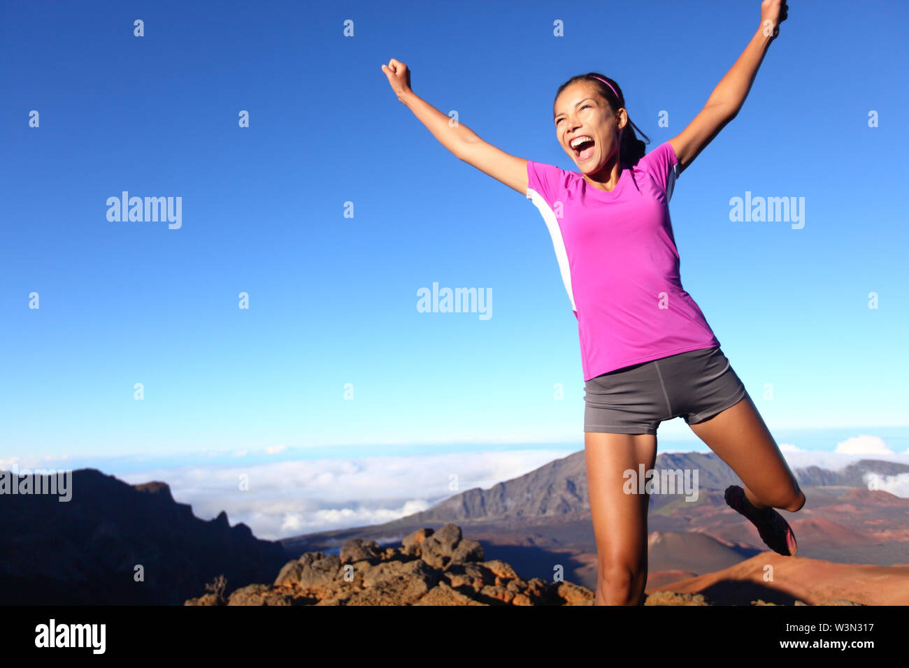 Success winner fitness runner woman jumping happy excited and energetic ...