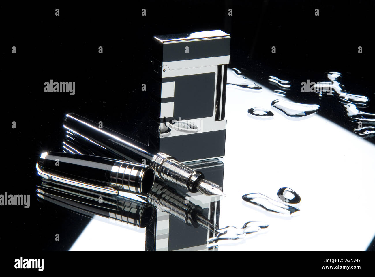 Lighter and pen on a glass background Stock Photo - Alamy