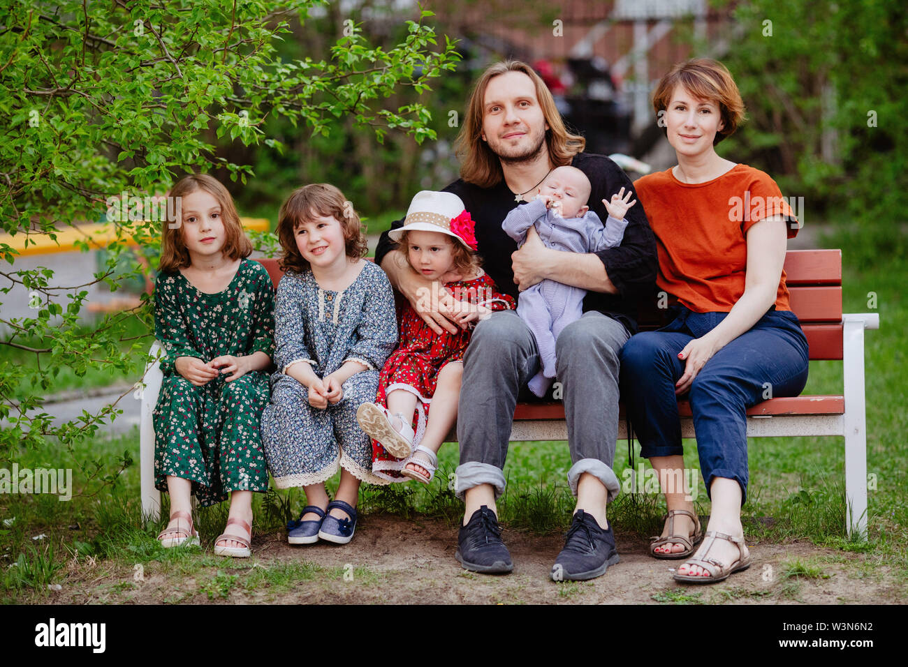 Family sitting together on bench Stock Photo - Alamy