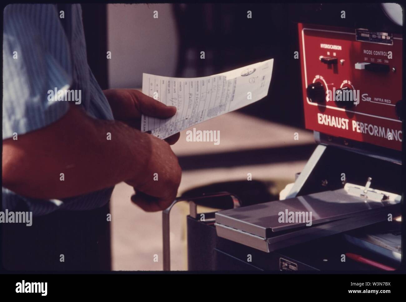 Closeup of an Employee Punching an Auto Emission Inspection Sheet at a ...