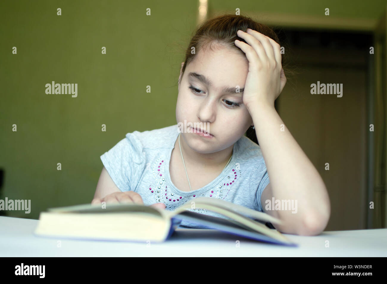 Unhappy teenager reading book hi-res stock photography and images - Alamy