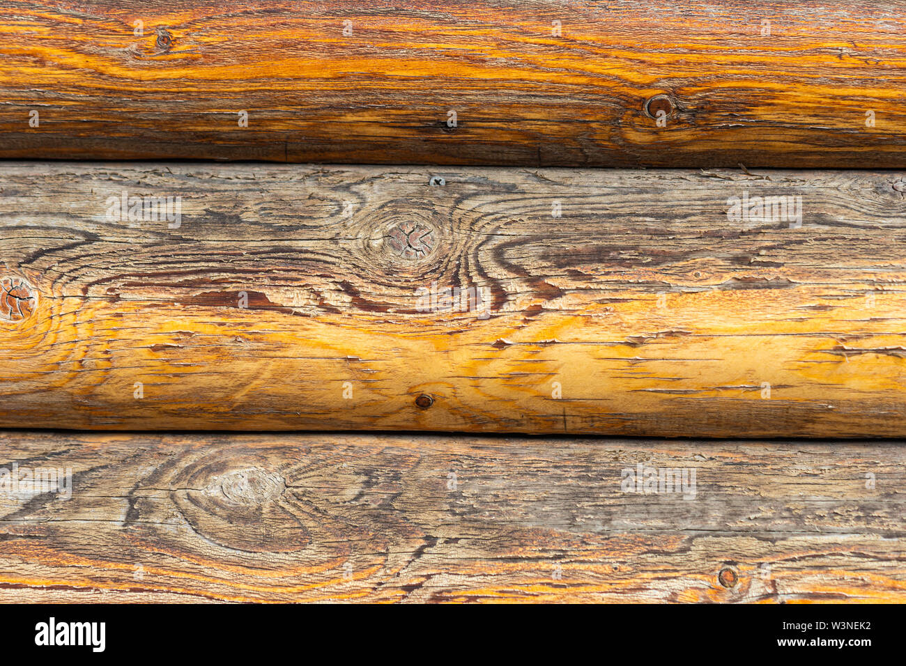 Closeup view of three rows of round logs of a wooden log cabin. Logs ...