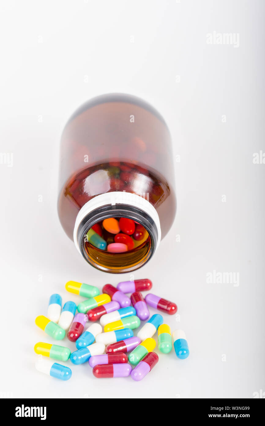 Pills pouring out of the brown bottle Stock Photo - Alamy